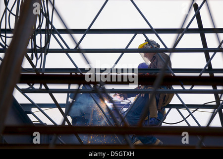 Ironworkers welding the steel framework of a building. One welding one ...