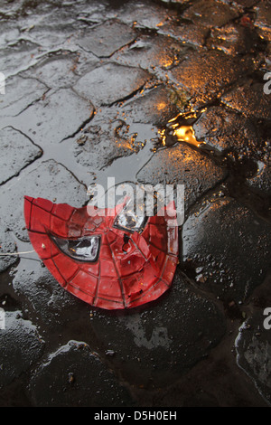 broken spiderman plastic mask on wet road in city town Stock Photo - Alamy