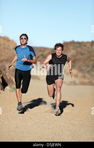 Male athletes sprinting. Two men in sport clothes run at the running ...