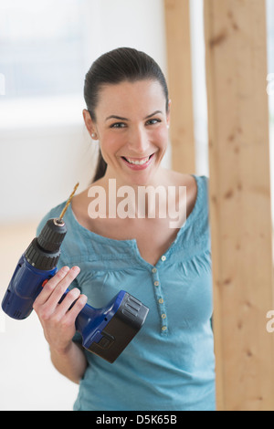 happy woman using hand drilling machine Stock Photo - Alamy