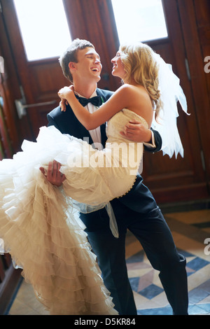 Caucasian groom carrying bride Stock Photo - Alamy