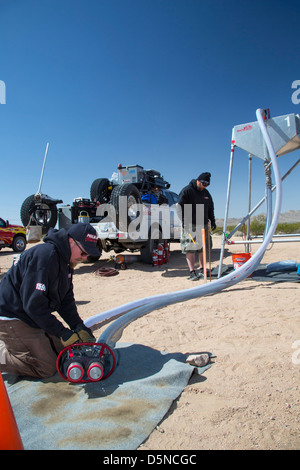 Pit crew refueling racing car with reflective helmet Stock Photo - Alamy