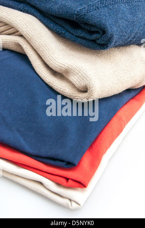 Pile of colorful warm clothes on the grey sofa Stock Photo - Alamy