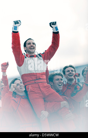 Formula one racing team cheering for driver with trophy, celebrating ...