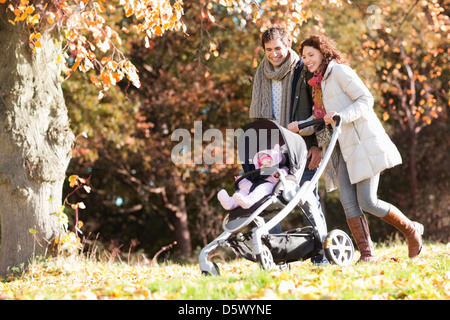 Woman pushing a stroller and looking at her baby. Mother taking her ...