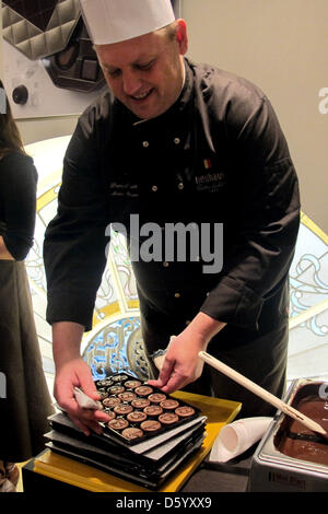 Neuhaus maitre chocolatier Olivier Demol works with liquid chocolate at ...