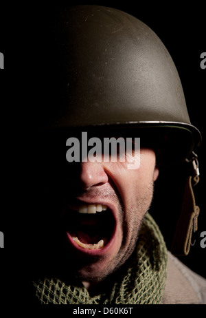 Portrait of a WW2 U.S. soldier shouting, with deep shadows against a ...