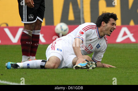 Hamburg's Gojko Kacar lies on the pitch injured next to team-mate ...