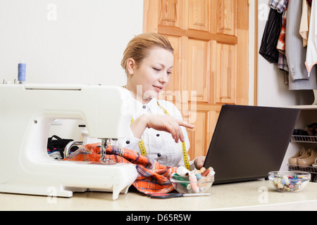 A sewer working on a laptop computer Stock Photo - Alamy