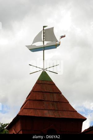 A wind vane on a shingled roof with the arrow pointing north ...