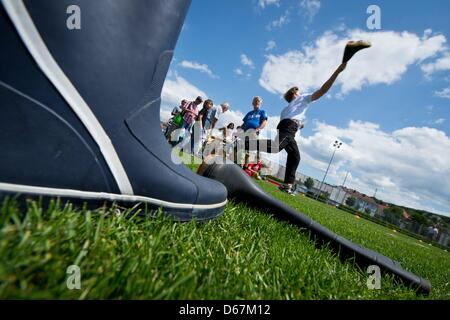 A participant throws a boot during the rubber boot throwing ...