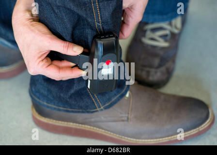Probation officer puts an electronic monitoring device on the ankle of ...