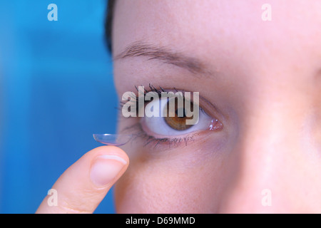 Young woman inserting contact lenses to eye Stock Photo - Alamy