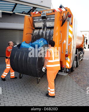 Stuttgart waste management workers load a garbage truck in Stuttgart ...