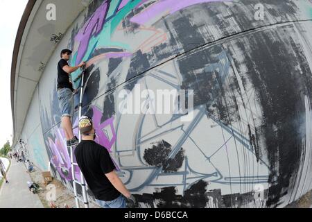 Artists spray graffitis on one of Germany's largest legal graffiti wall ...