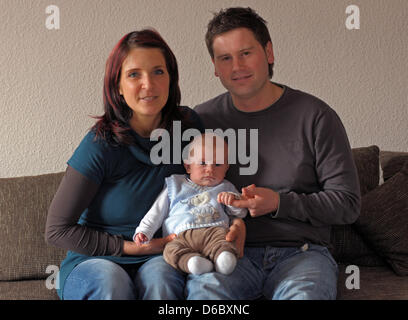 Caroline Welz and Lars Held sit together with their three-month-old ...