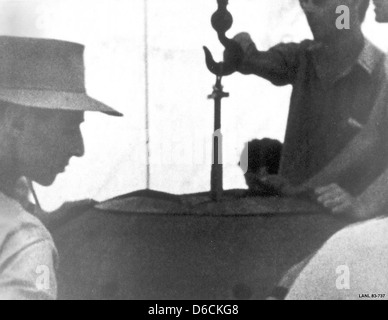 This image depicts J. Robert Oppenheimer overseeing the final assembly ...