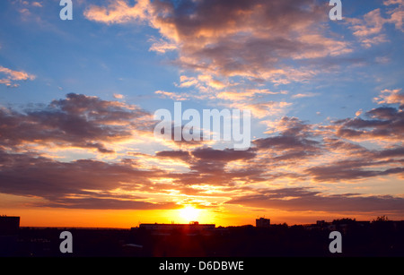 Sunset on a blue and yellow cloudscape sky with winter tree branches ...
