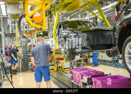 Several employees of car manufacturer BMW work on a car at the BMW ...