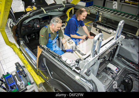 Several employees of car manufacturer BMW work on a car at the BMW ...