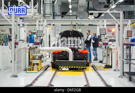 Several employees of car manufacturer BMW work on a car at the BMW ...