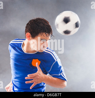 Soccer player hitting a ball with his head Stock Photo - Alamy