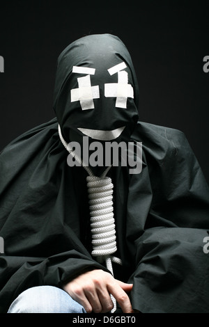 Black mime with rope on neck on black background reading book Stock ...