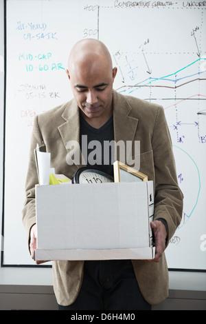 Businessman packing up box in office Stock Photo - Alamy