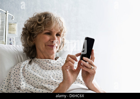 Female hospital patient using cellphone Stock Photo - Alamy