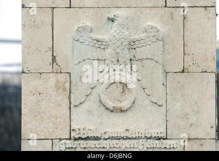 An imperial eagle holding a wreath (with a removed swastika) is carved ...