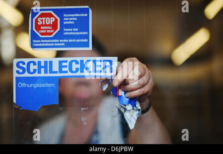 Schlecker employee Birgit Strahl rips the company logo from the ...