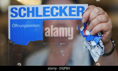 Schlecker employee Birgit Strahl rips the company logo from the ...