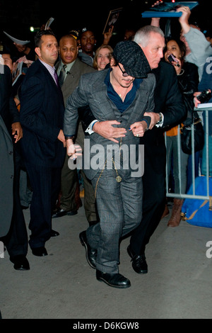 Johnny Depp is pulled away by his security guard while signing ...