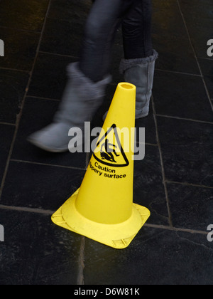 Yellow Caution Slippery Surface cone Stock Photo - Alamy