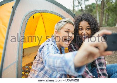 Happy and excited black female holding her mobile phone, jubilating ...