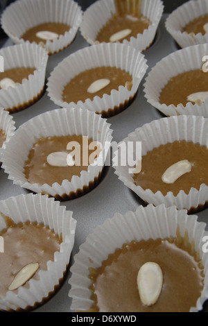 Homemade sweet bun with honey almonds on a white wooden background ...