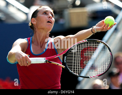 Flavia Pennetta of Italy serves to Maria Sharapova of Russia on day 5 ...