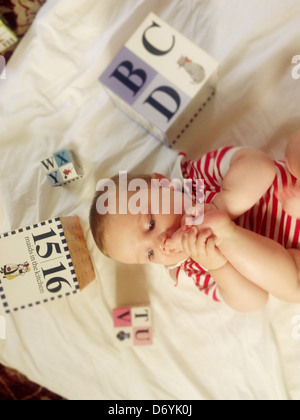 Caucasian baby boy biting foot Stock Photo - Alamy