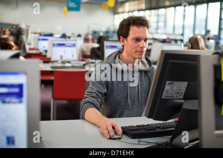 Young student man using computer very happy pointing with hand and ...