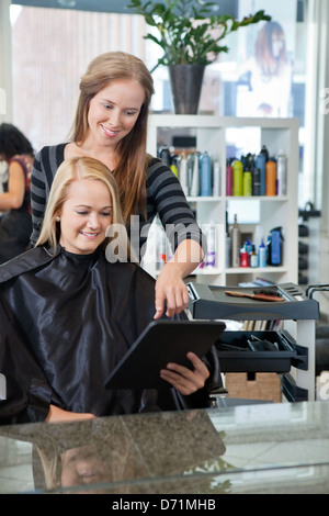 Hair salon, woman and smile with tablet at work for client, information ...