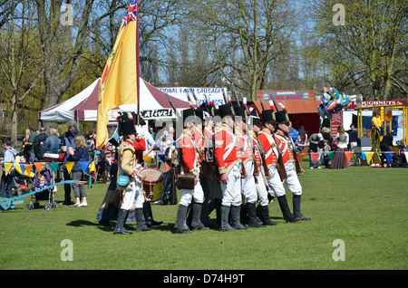 Redcoat soldiers marching near to camera in reenactment with flag Stock ...