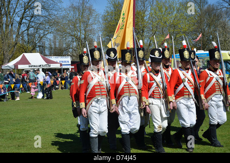 Redcoat soldiers marching towards camera in reenactment with flag Stock ...