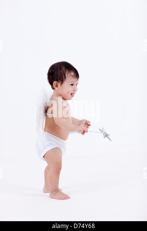 a baby standing with angel wings in the back Stock Photo - Alamy