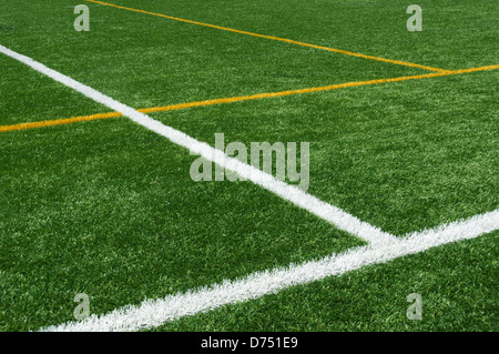 The white chalk lines on the turf of a soccer field cross each other ...