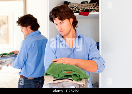Man organizing clothes in cupboard Stock Photo - Alamy