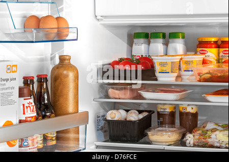 Cooled food and beverages in open fridge / refrigerator in kitchen ...