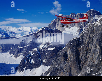 K2 Aviation's Cessna 185 on wheel skis flying above Kahiltna Glacier Mt ...