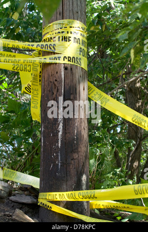 yellow police tape wrapped around and across objects. knotted and ...