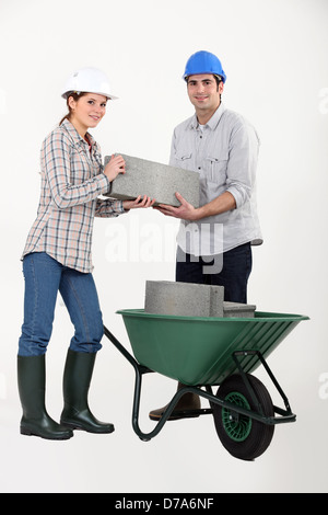Man carrying bricks in a wheelbarrow. Construction site. Laos Stock ...