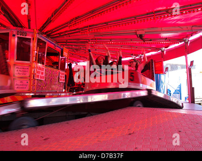 Teenage girls on a fairground waltzer ride with the operator in the ...